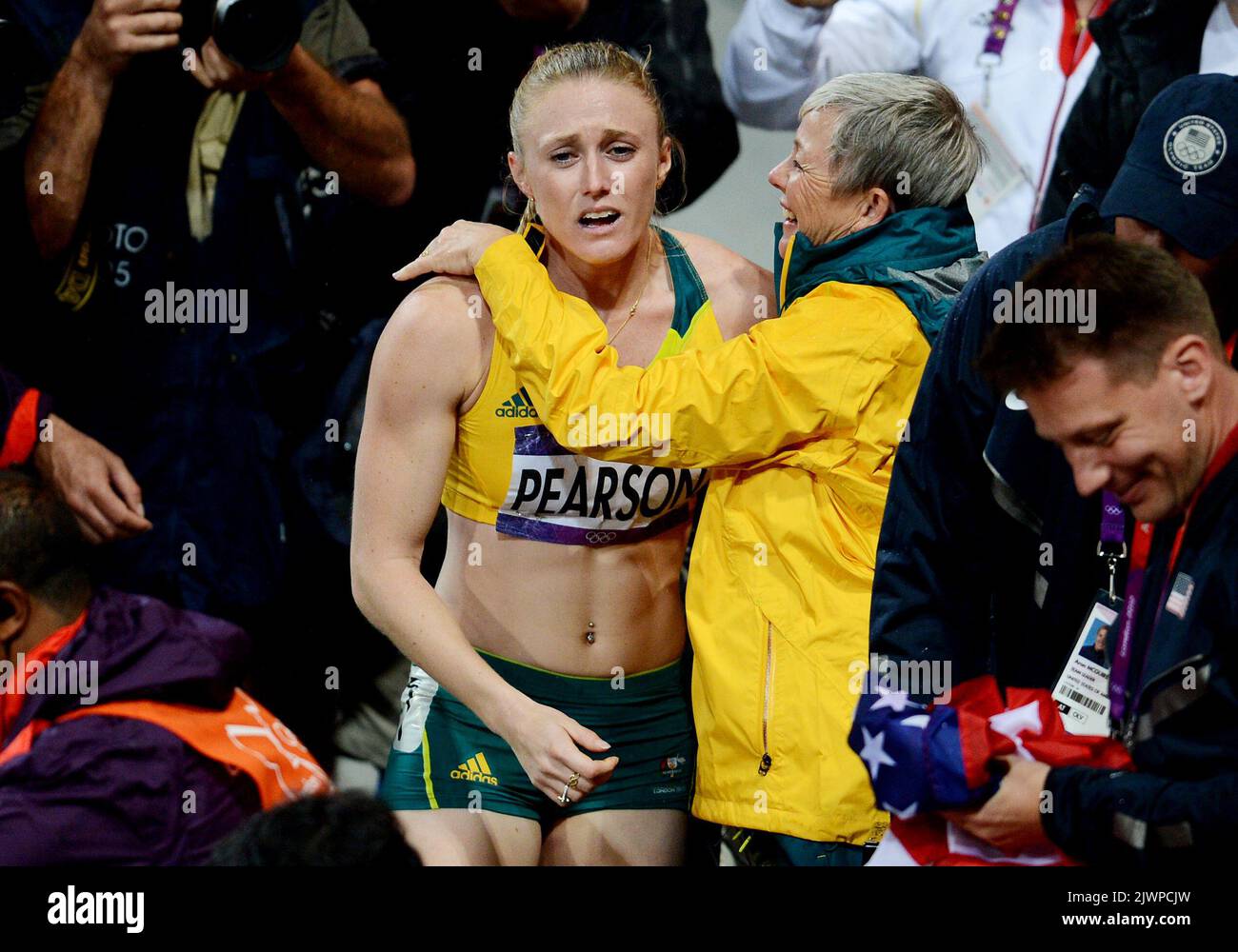 Sally Pearson of Australia (centre left) is hugged by her coach Sharon ...