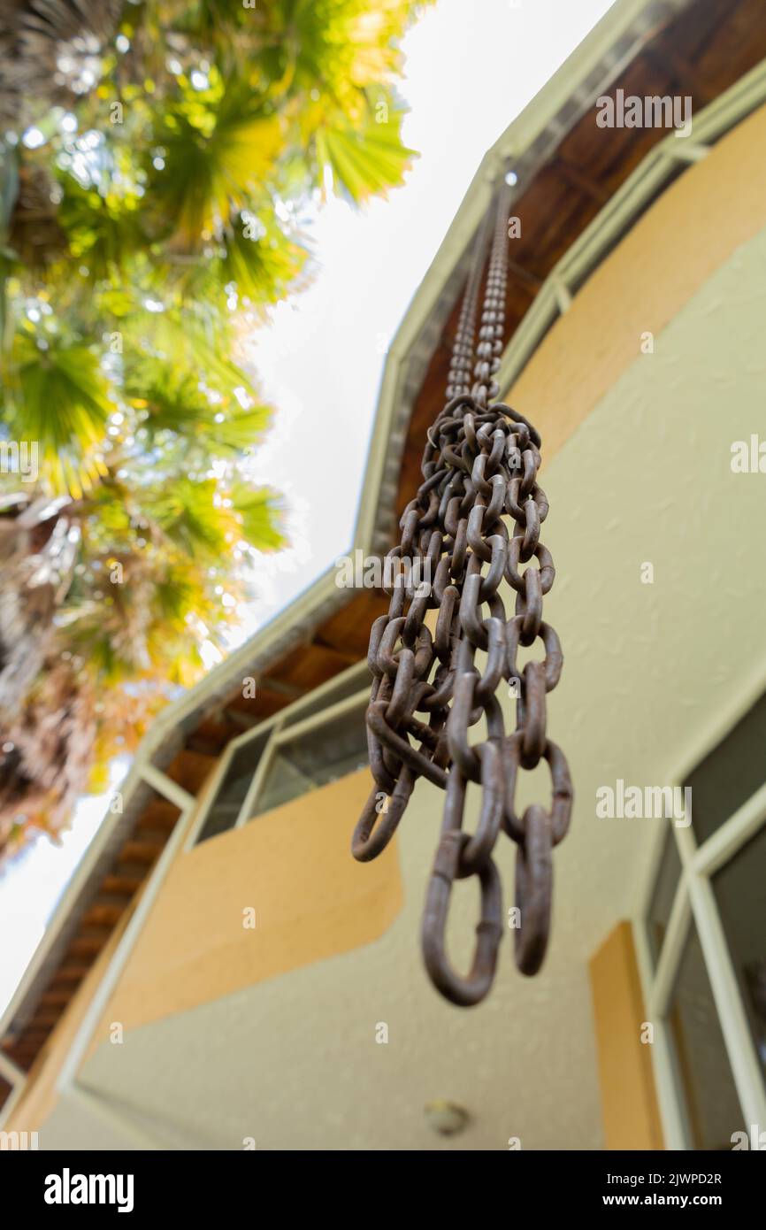 part of a house with a cream wall and a metal chain hanging in the ...