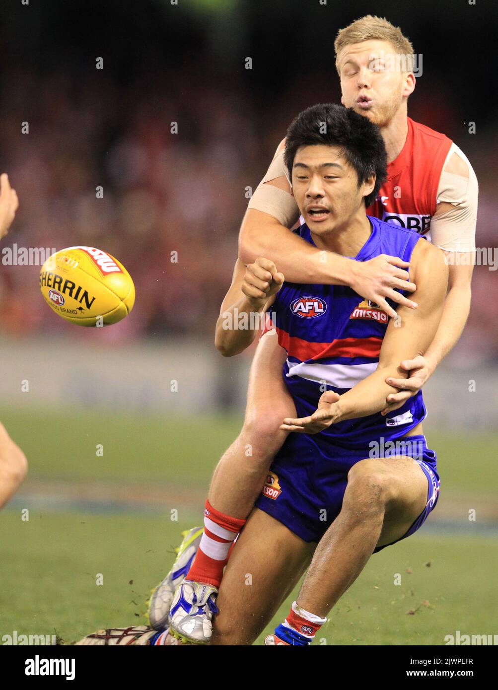 Lin Jong gets a hand ball away for the Bulldogs against Sam Reid for ...
