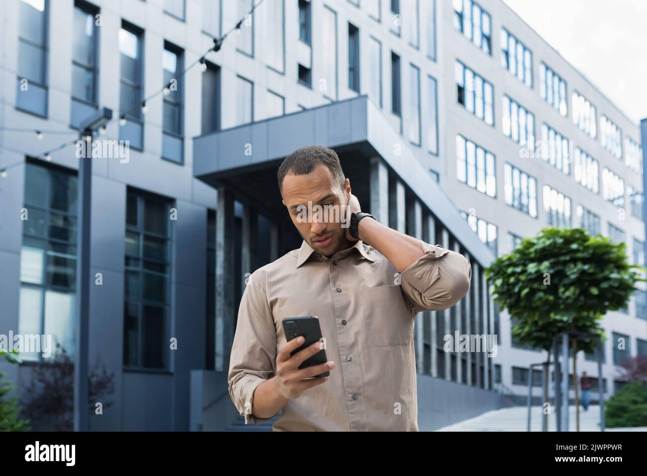 Pensive and excited african american worker outside office building ...