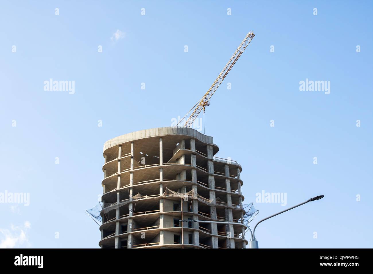 Construction crane and construction of a tall house Stock Photo - Alamy