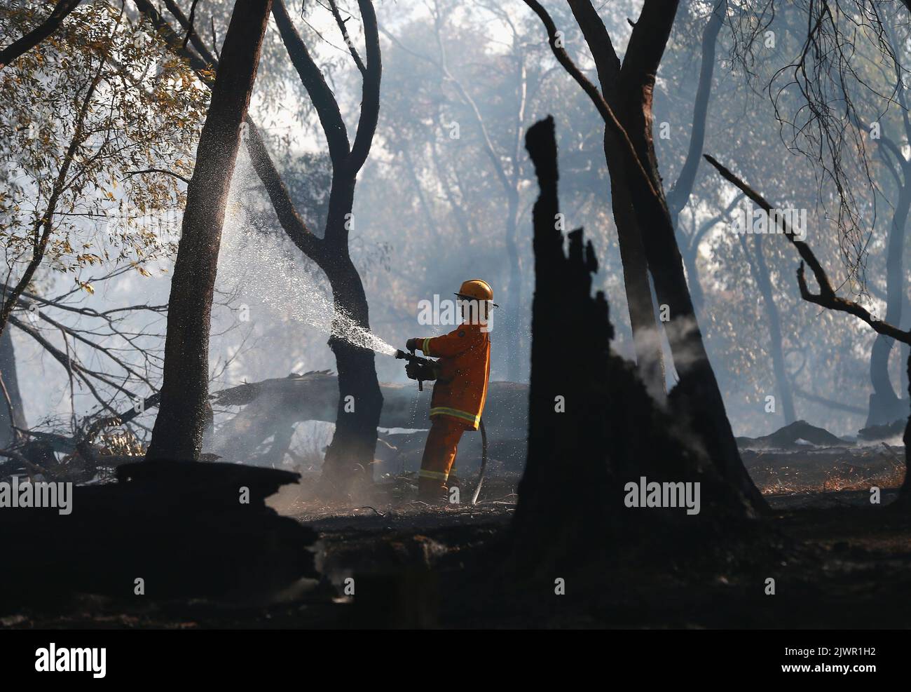 CFA firefighters mop up a fire at the end of Taylors Lane in Wallan on ...
