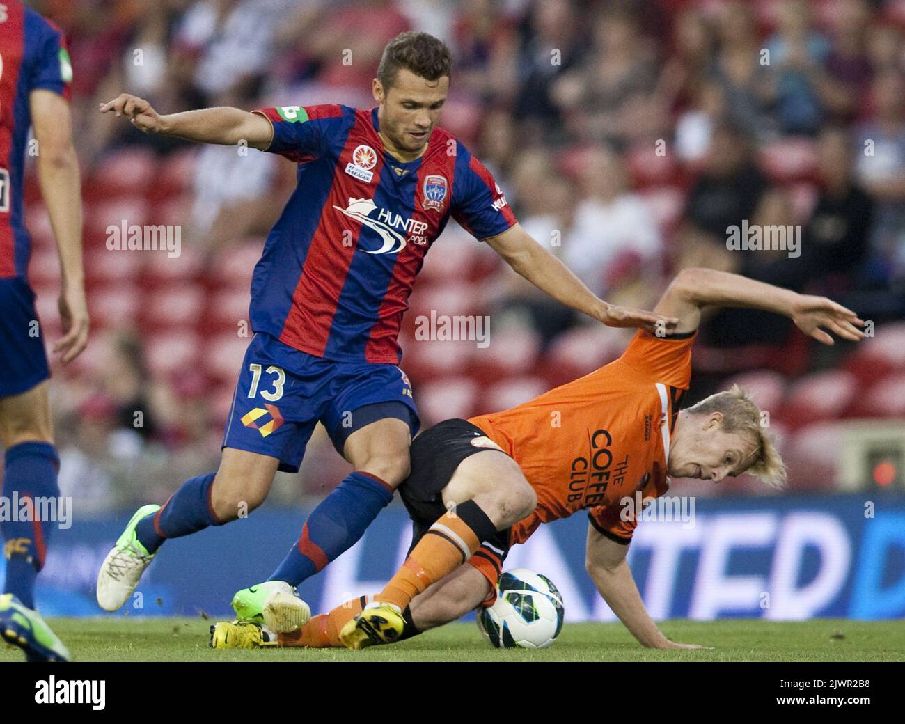 Samuel Gallaway of Newcastle Jets FC is challenged by Ben Halloran of ...