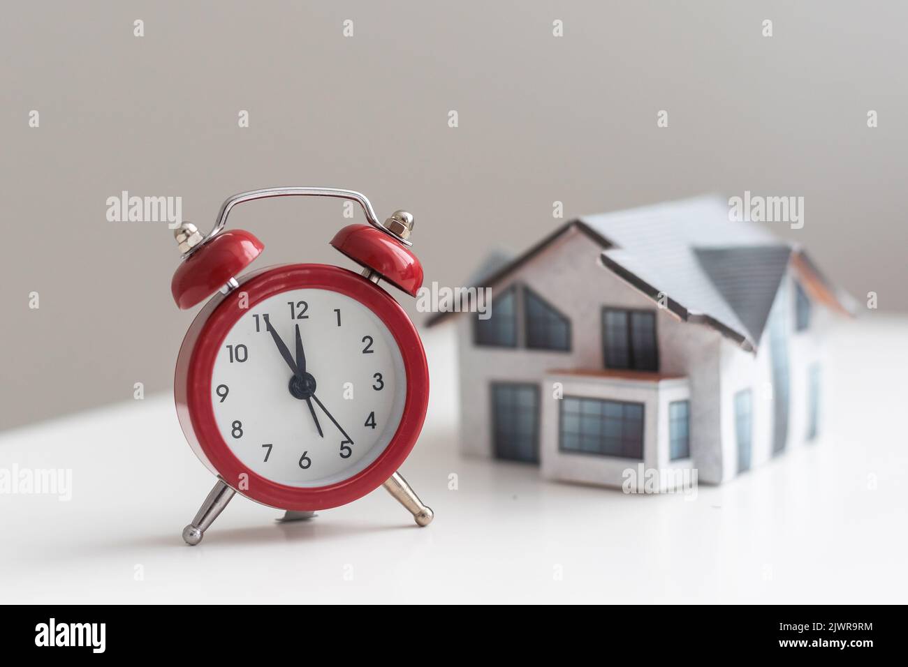 Toy House and alarm clock isolated on white Stock Photo - Alamy