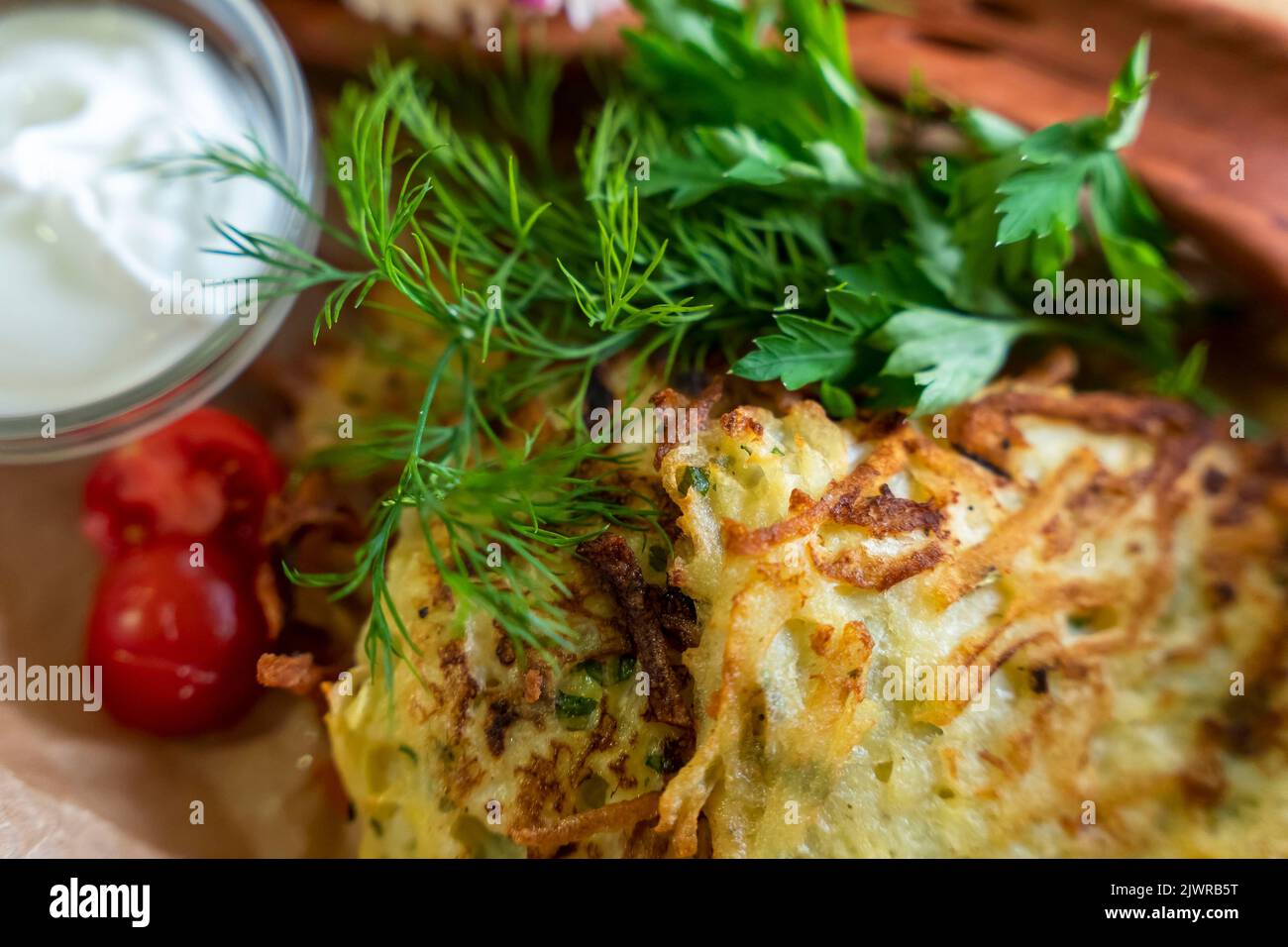 Draniki served with sour cream and herbs in the restaurant Stock Photo ...
