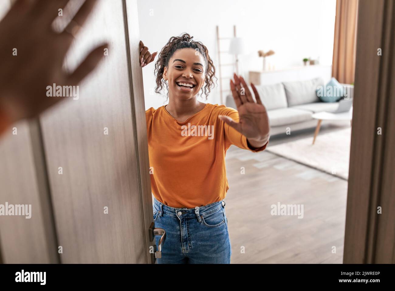 Cheerful African American Woman Waving Hand Meeting Somebody At Home ...