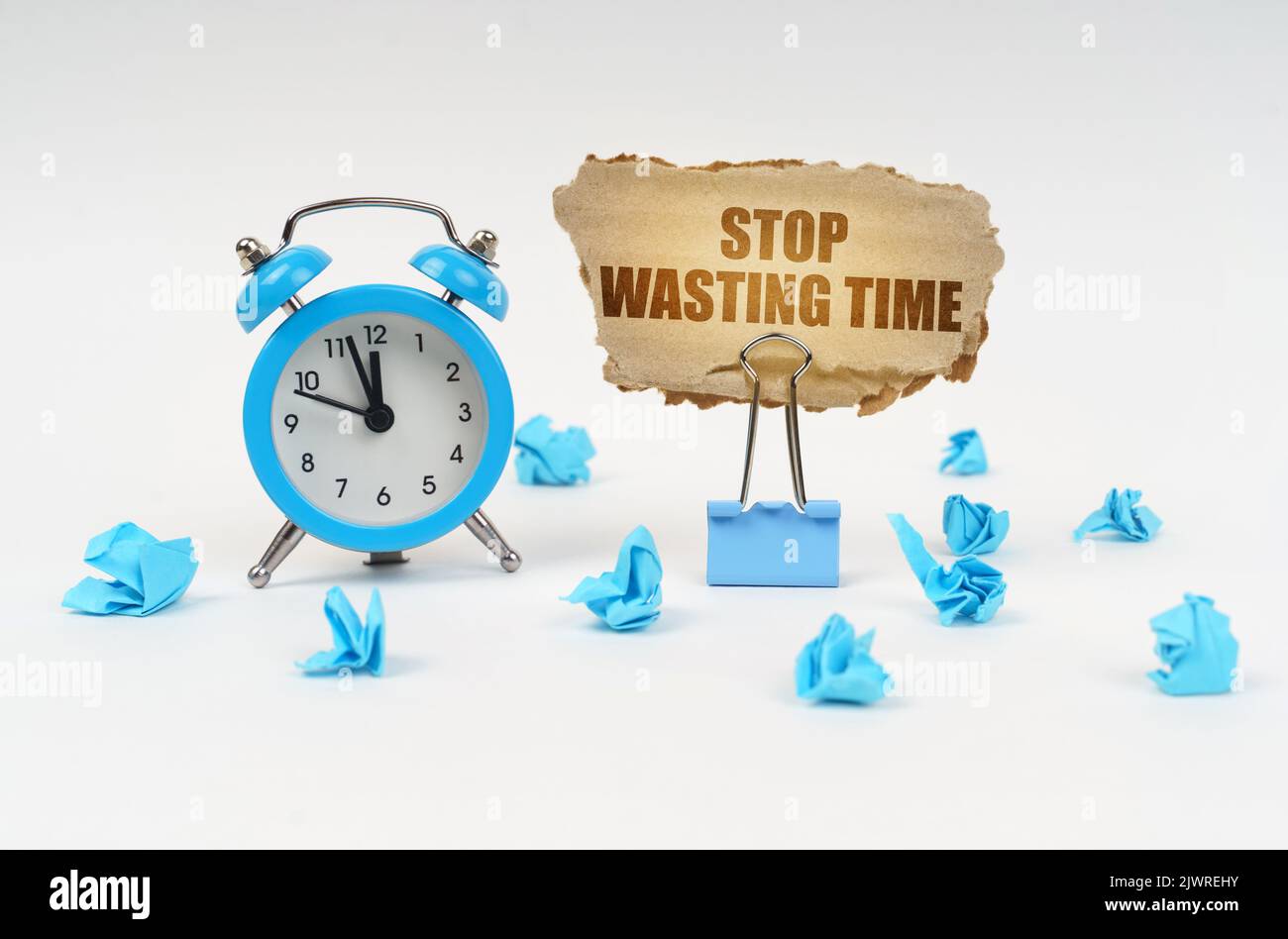 Time concept. On a white surface, an alarm clock, an office clip ...