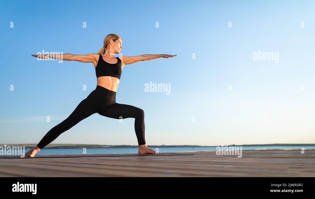 Beautiful Middle Aged Woman Practicing Yoga Outdoors, Standing In ...
