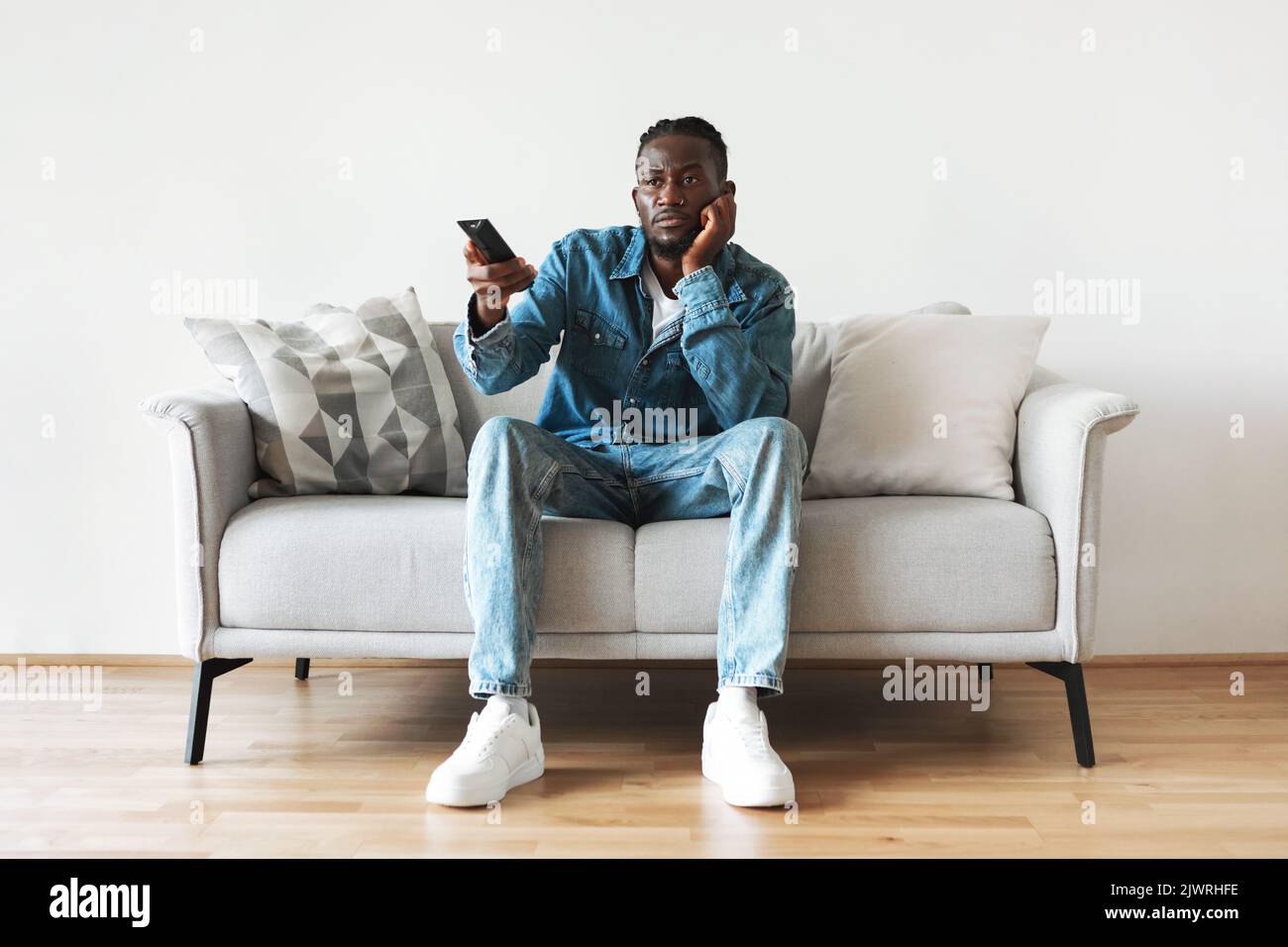 Bored Black Guy Watching Movie On TV Sitting At Home Stock Photo - Alamy