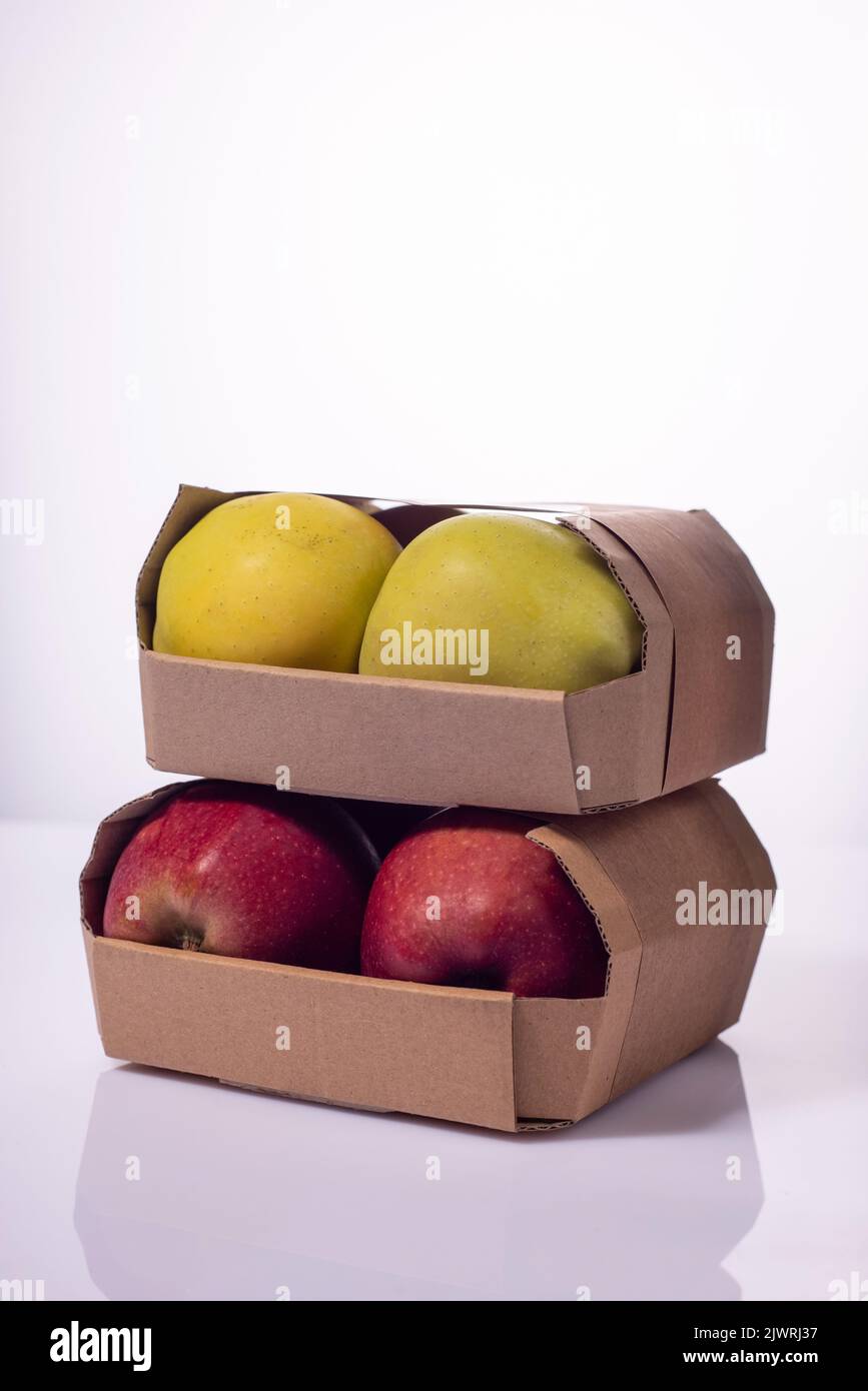 paper packages of yellow and red apples on a white background Stock ...