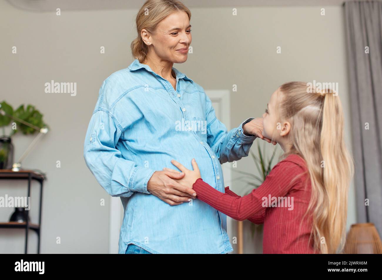 Happy expectation concept. Little girl touching mother's pregnant belly ...
