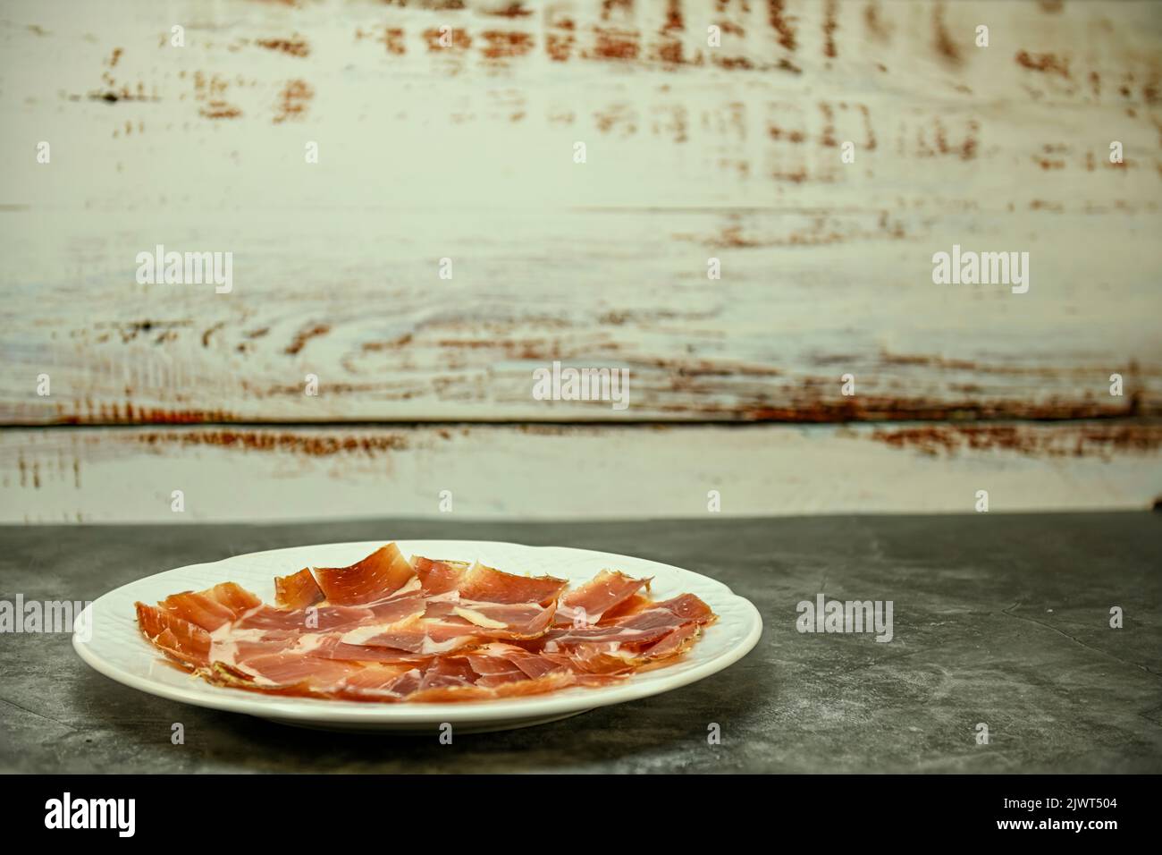 Plate of Serrano ham, freshly cut and served on a plate Stock Photo - Alamy