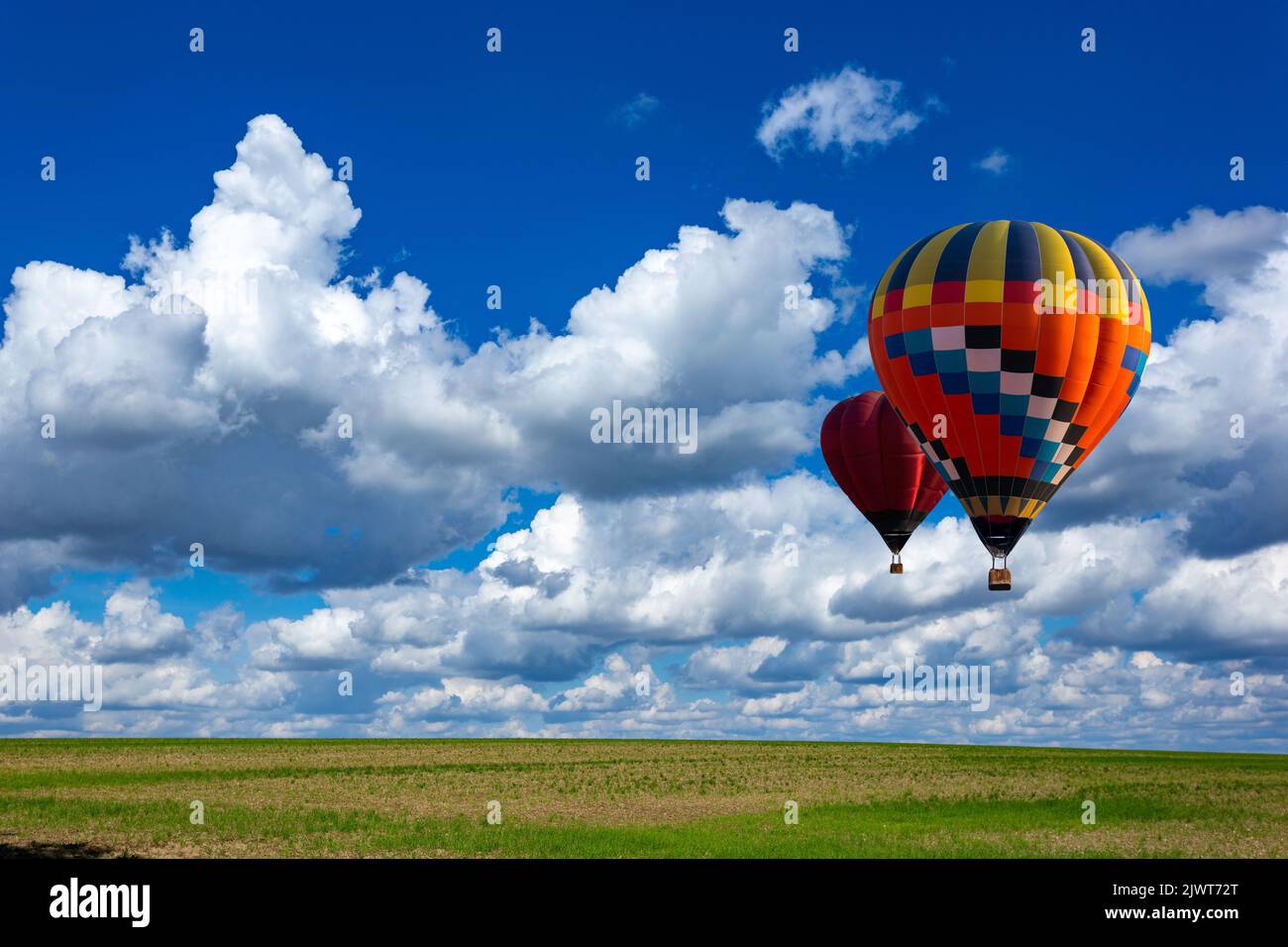 Colorful hot air balloons over green rice field Stock Photo - Alamy