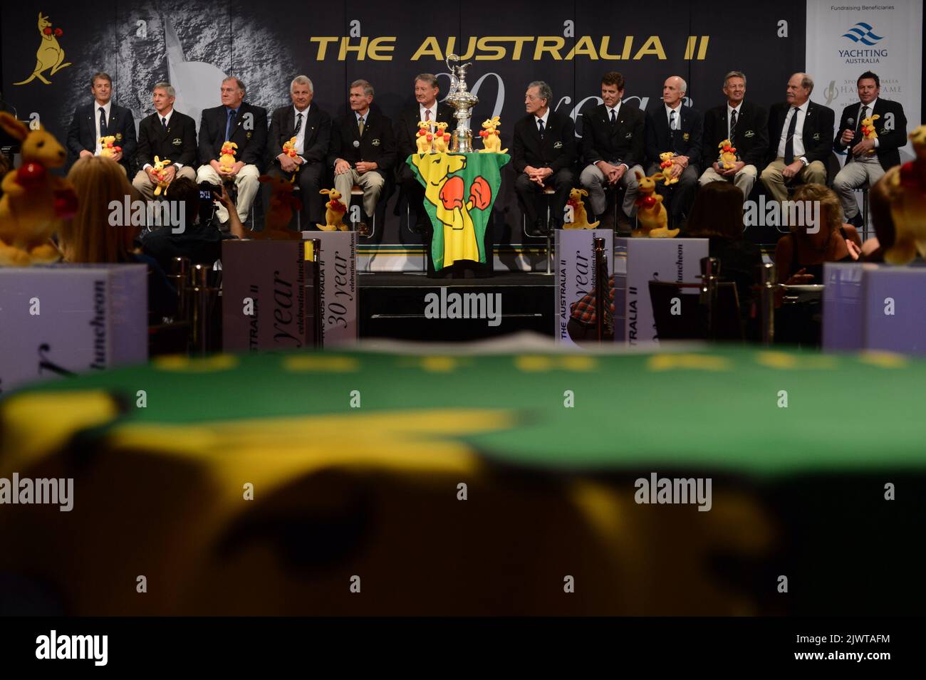 The crew of Australia II on stage with a replica of the America's Cup ...