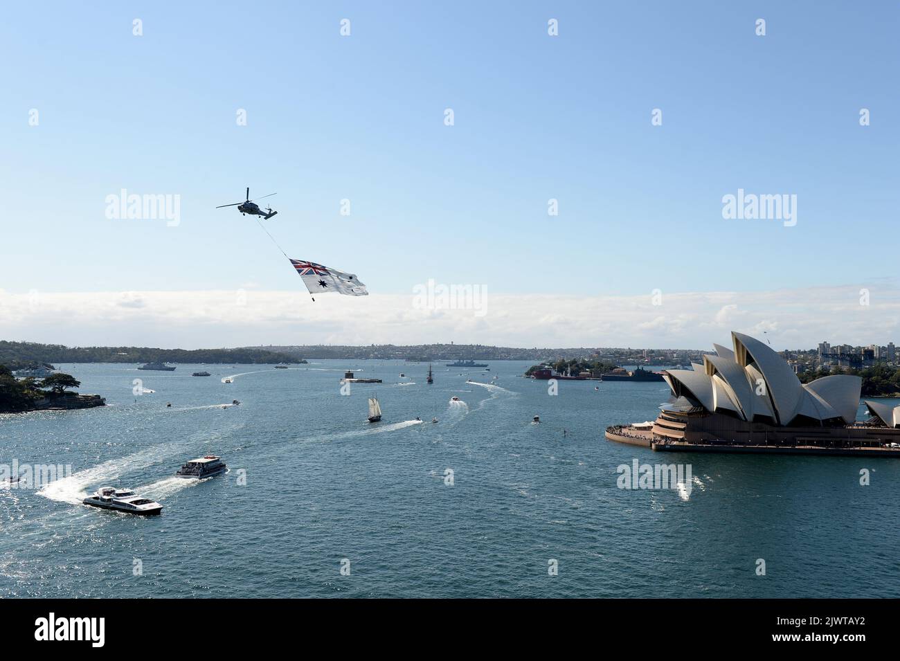 A Royal Australian Navy Seahawk helicopter flies the navy's white ...