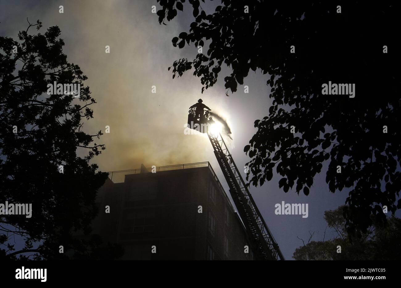 A firefighter at the scene of a fire on the roof of a residential ...