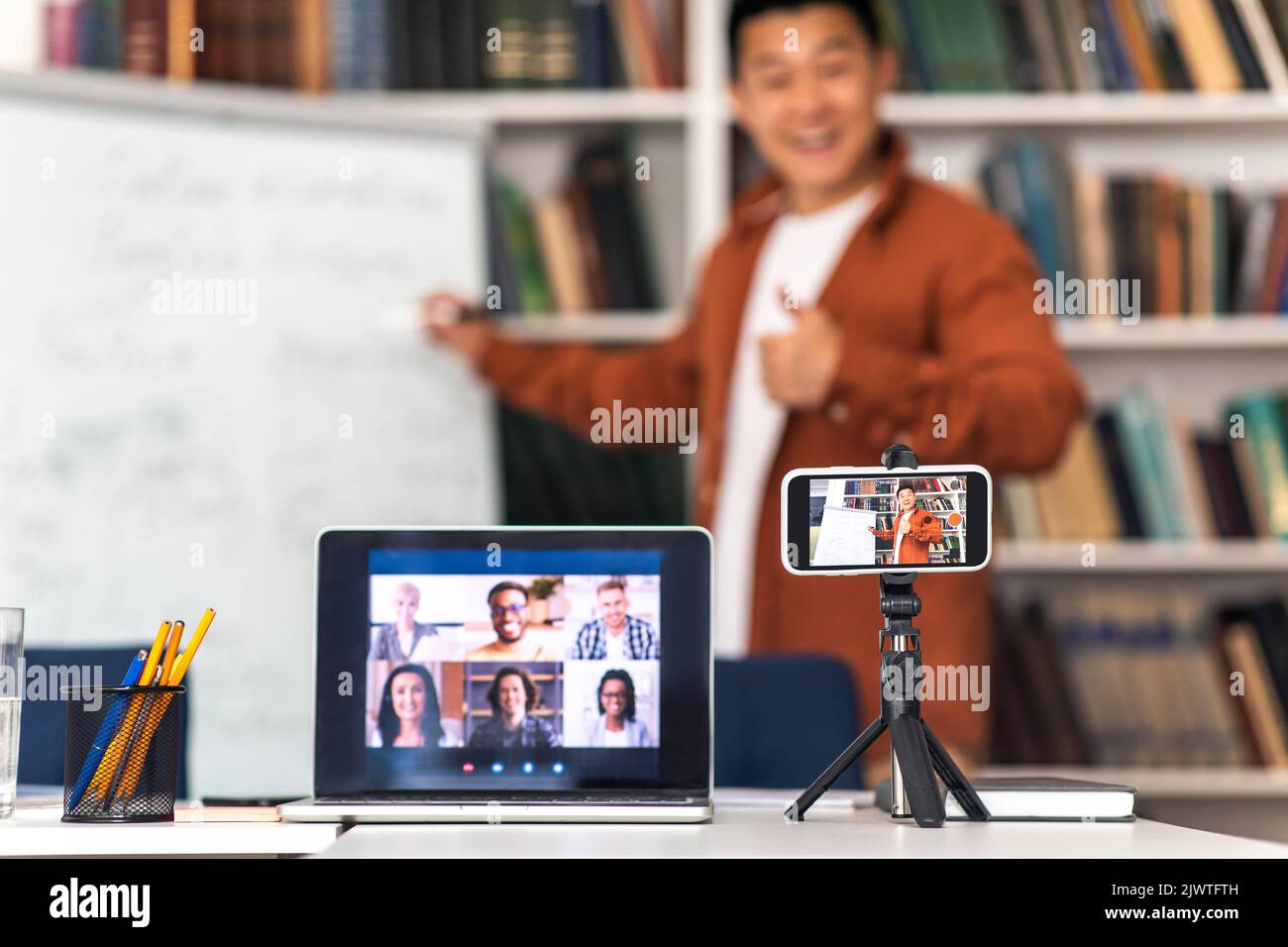 Asian Teacher Man Teaching Talking To Laptop And Smartphone Indoor ...