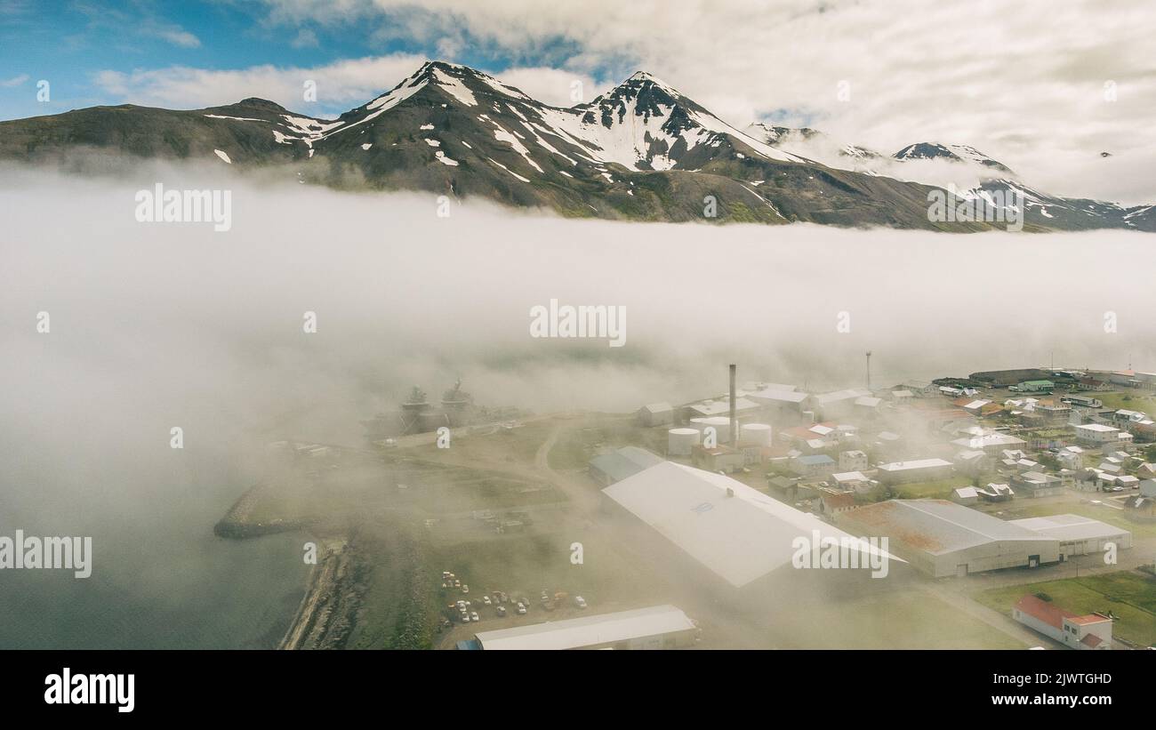 Morning fog above small town in the middle of mountains in Northern ...