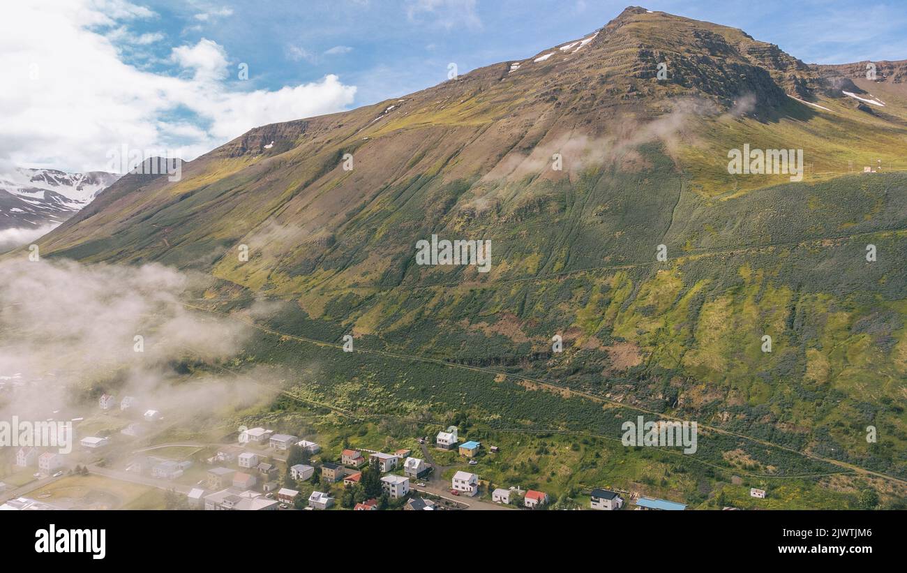 Morning fog above small town in the middle of mountains in Northern ...