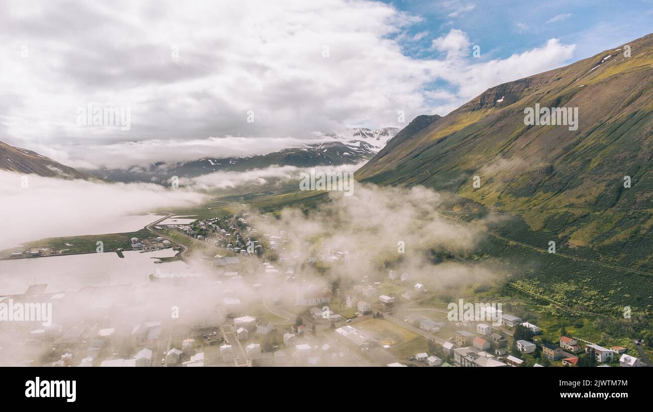 Morning fog above small town in the middle of mountains in Northern ...