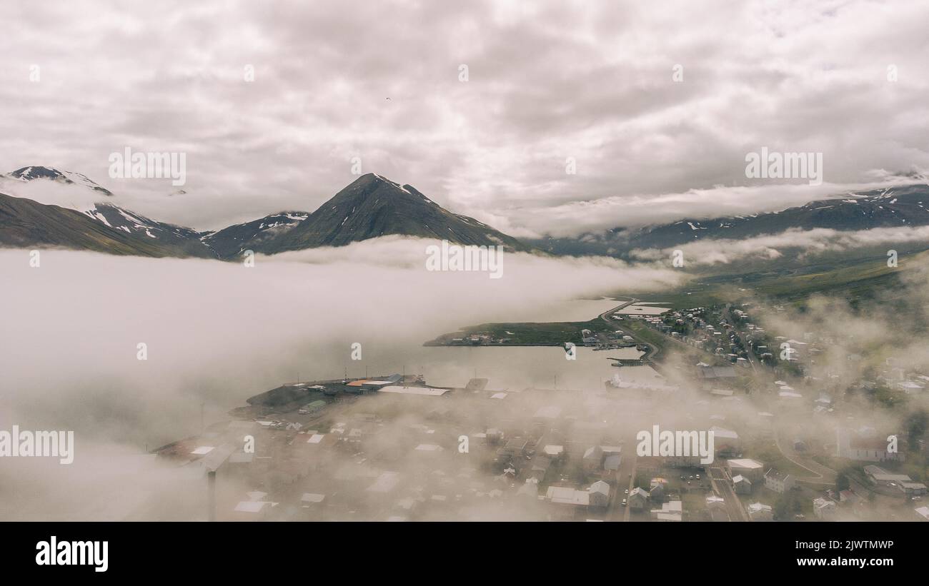Morning fog above small town in the middle of mountains in Northern ...