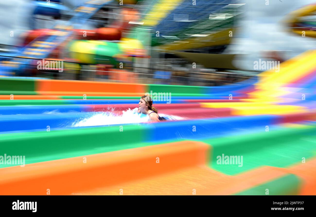 A girl rides a waterslide on opening day at the Wet N Wild theme park ...