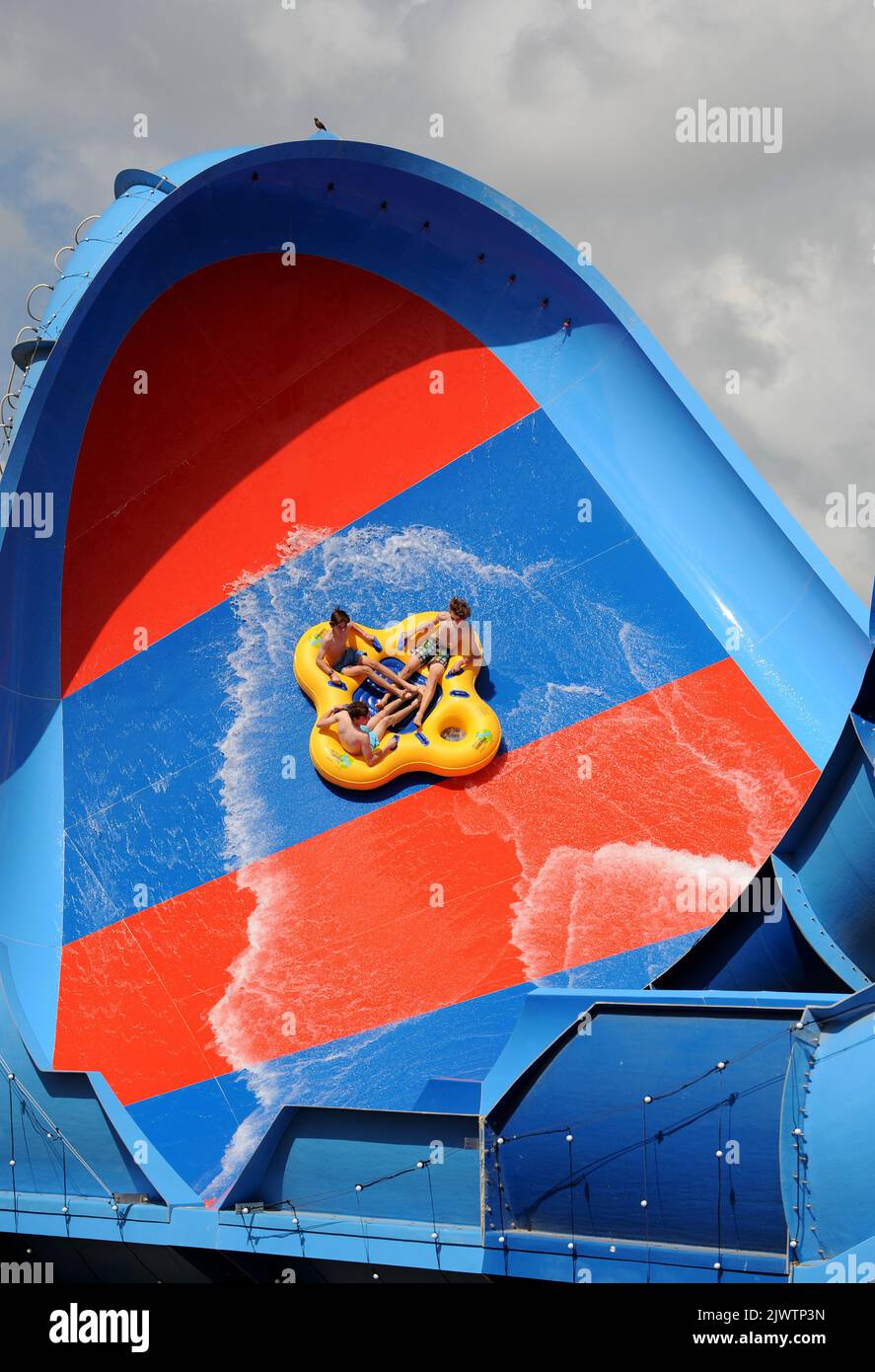 People ride a waterslide on opening day at the Wet N Wild theme park at ...