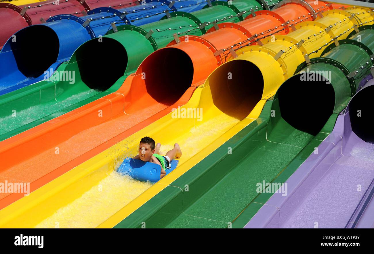 A young boy rides a waterslide on opening day at the Wet N Wild theme ...