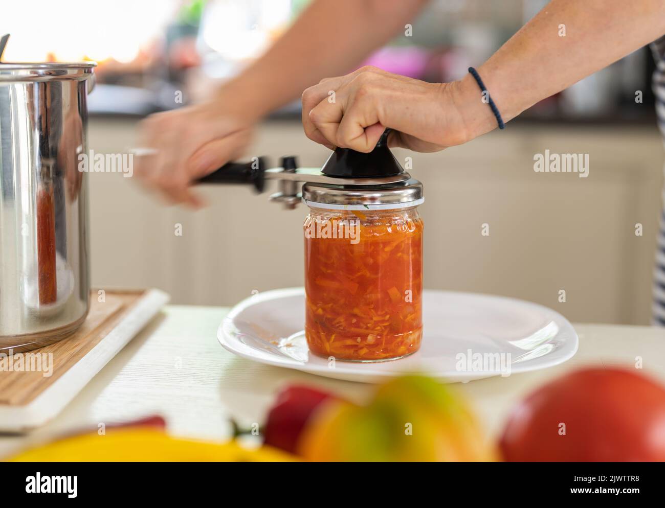 Home canning of vegetables. A woman in close-up preserves a vegetable ...
