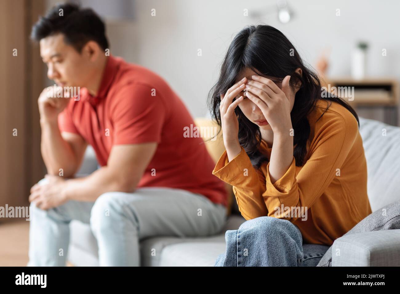 Upset chinese couple having fight, home interior Stock Photo - Alamy