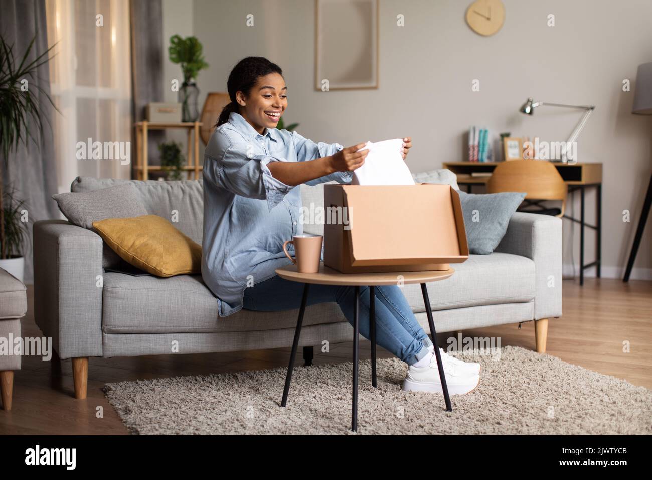 Joyful Pregnant Black Woman Unpacking Delivered Box With Clothes ...