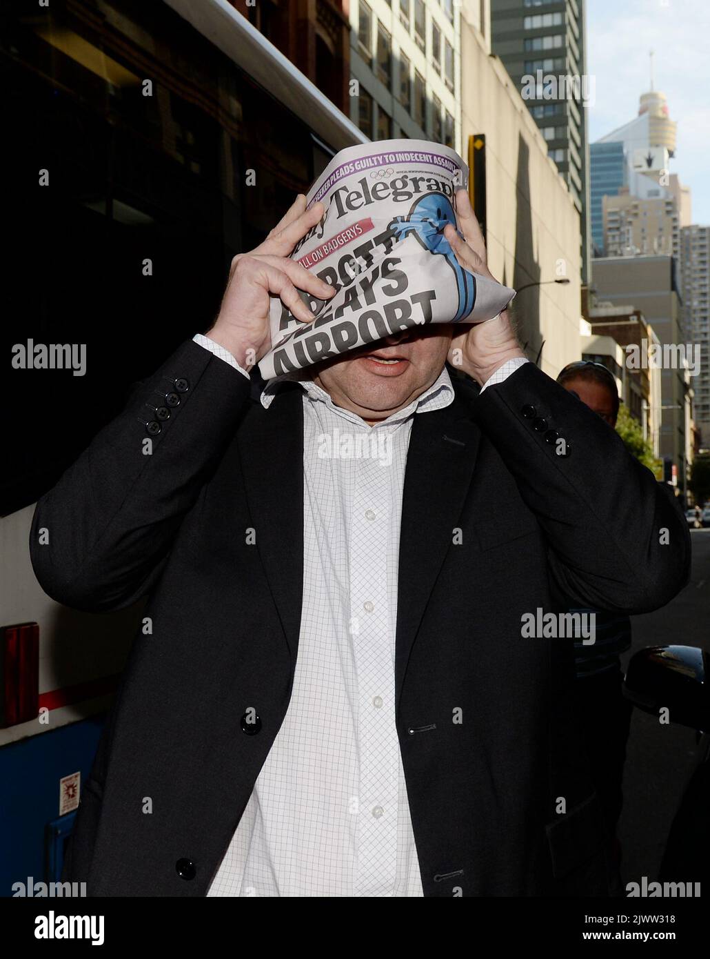 Mark Anthony Warren covers his face with a newspaper as he leaves the ...
