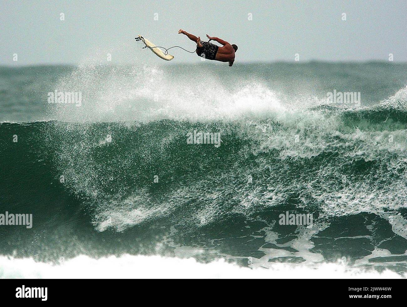 A surfer enjoys the 3 metre swell whipped up by tropical Cyclone Grace ...