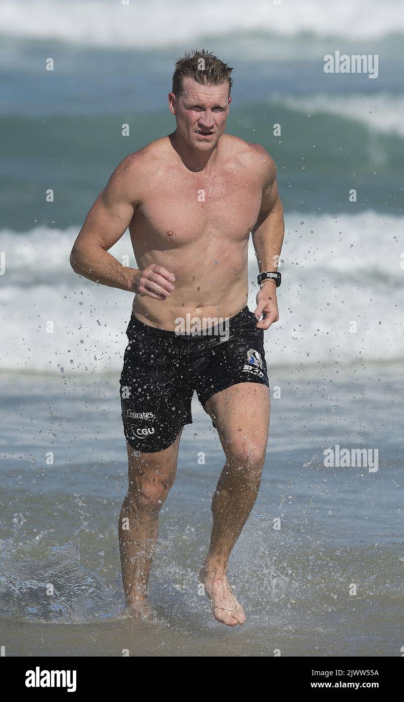 Collingwood football club coach Nathan Buckley runs from the surf ...