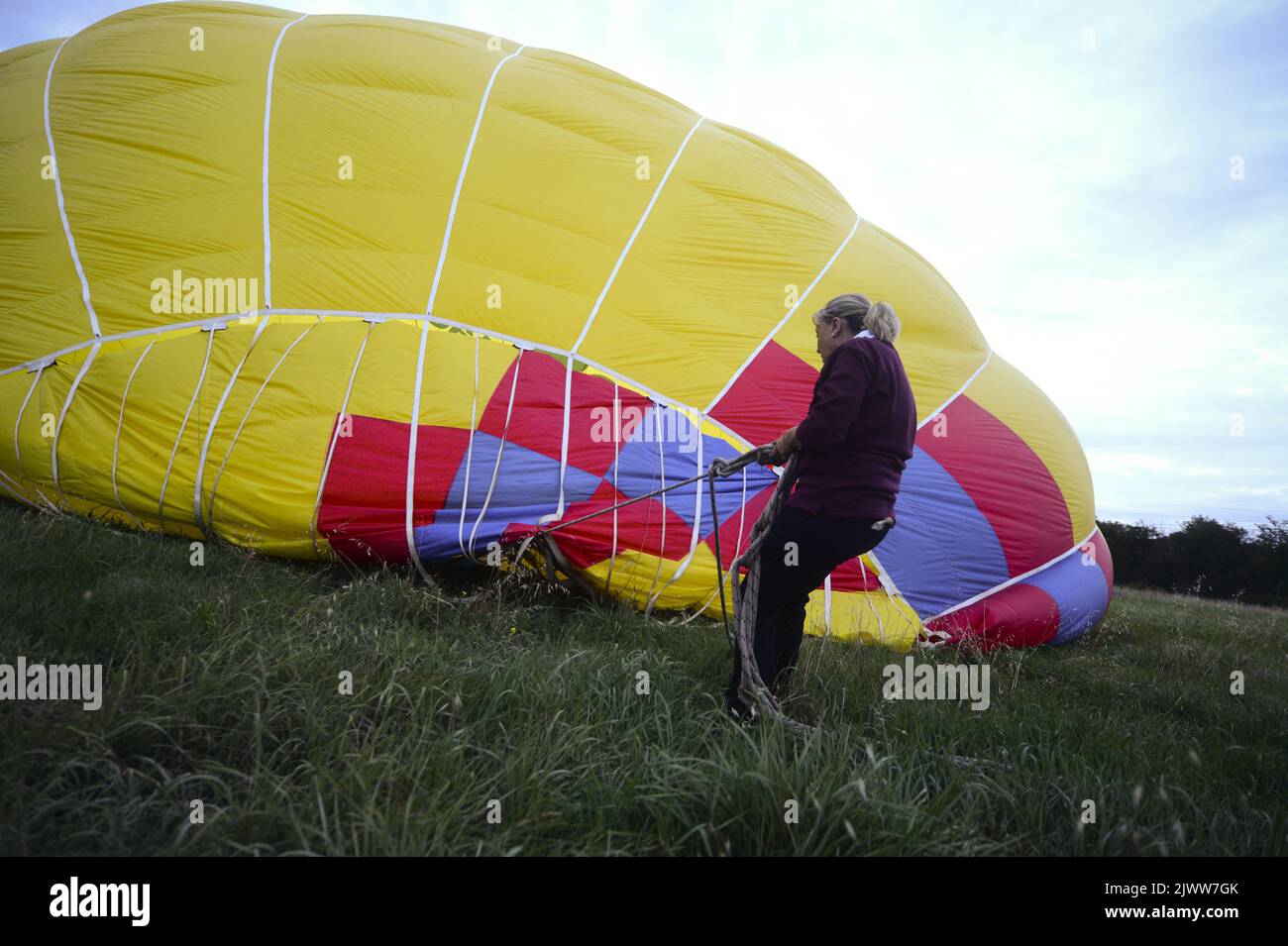 A member of the hot air balloon crew prepares the balloon for take off ...