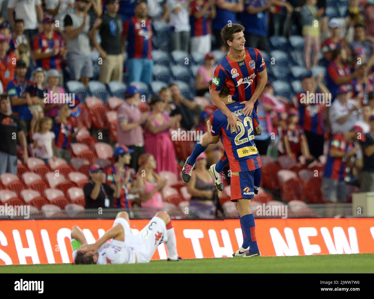 Adam Taggart of the Newcastle Jets lifts team mate Mitchell Oxborrow ...