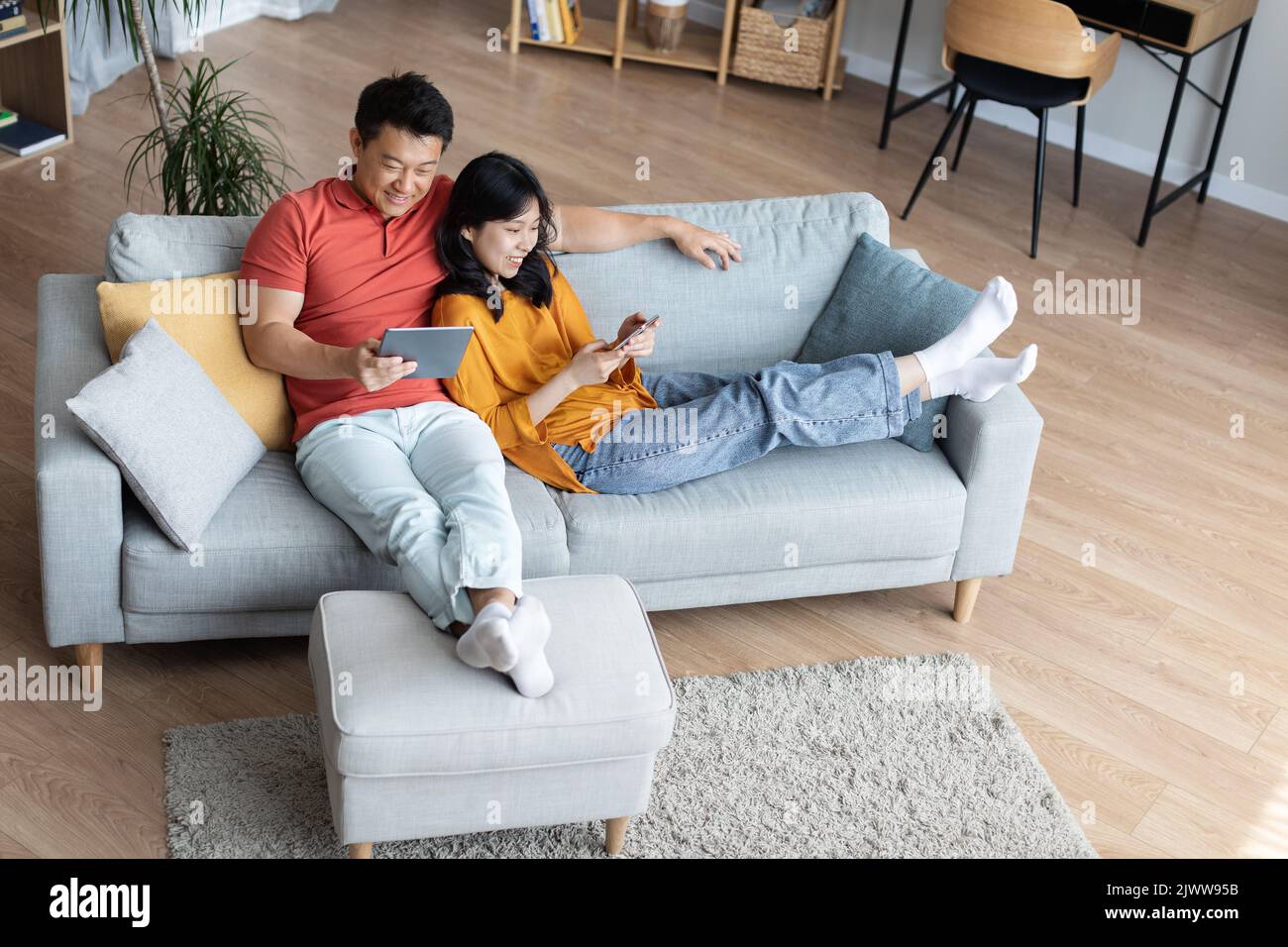 Top view of couple chilling together at home, using gadgets Stock Photo ...