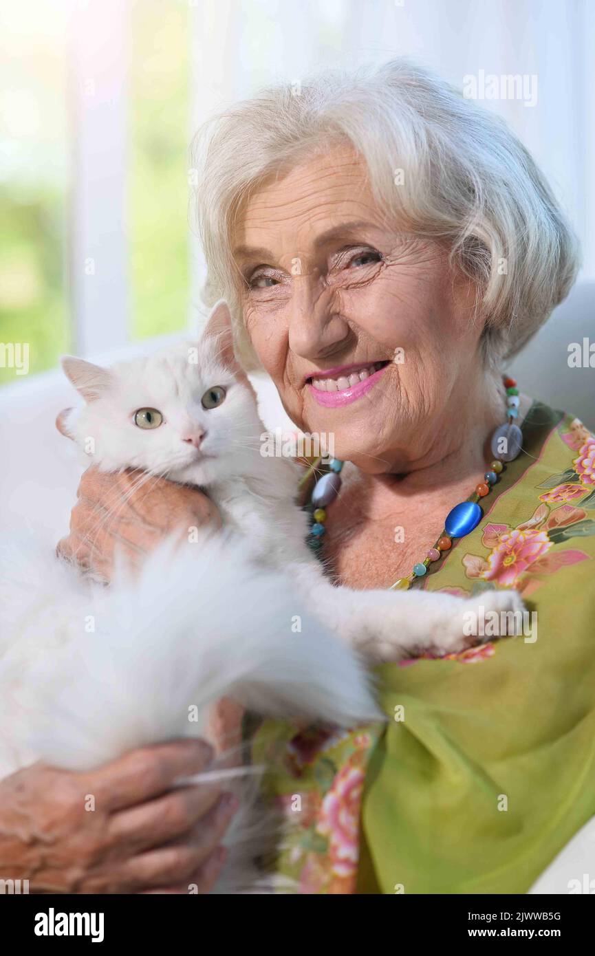 beautiful elderly woman holding a white cat Stock Photo - Alamy