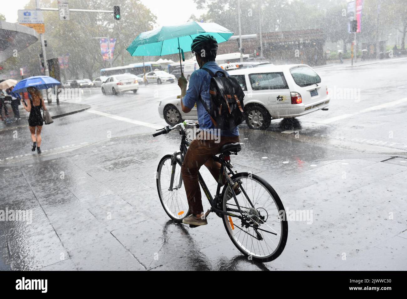 Pedestrians rush across the road during heavy rain in Sydney on Monday ...
