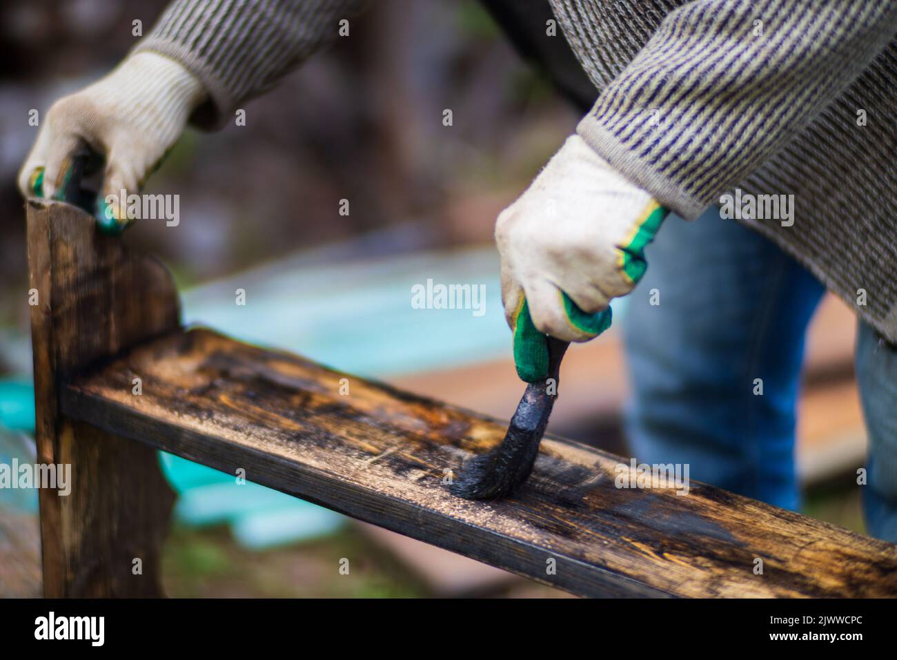 A man applies paint to a wooden surface with a brush. Lacquer work ...