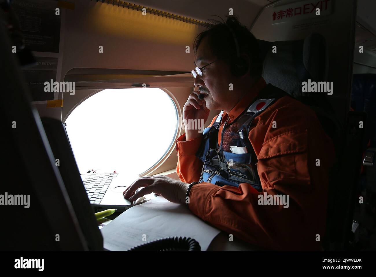 Hidetaka Sato of the Japan Coast Guard works the communications desk on ...