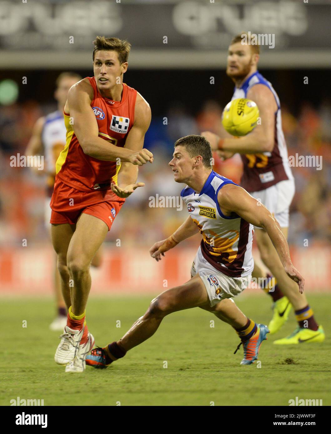 David Swallow of the Gold Coast handballs away from Brisbane players ...