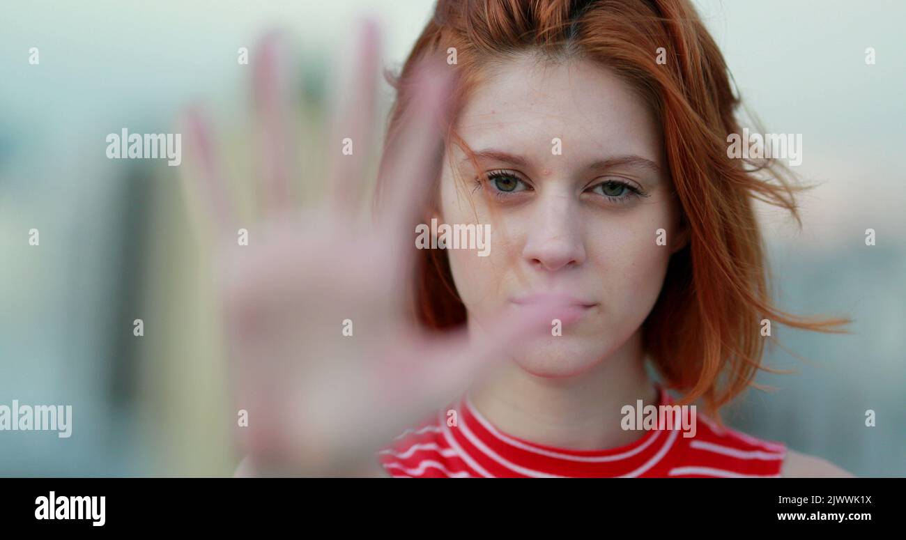Redhead woman annoyed making stop sign with hand, saying no, expressing ...