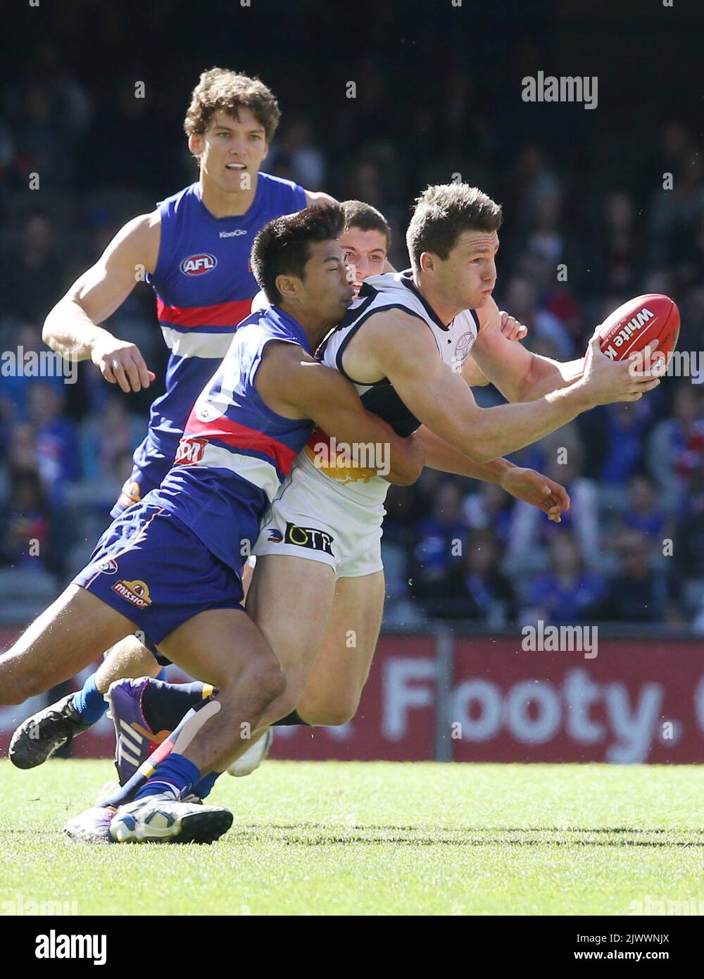 Matthew Fuller for the Bulldogs puts in a tackle on Patrick Dangerfield ...