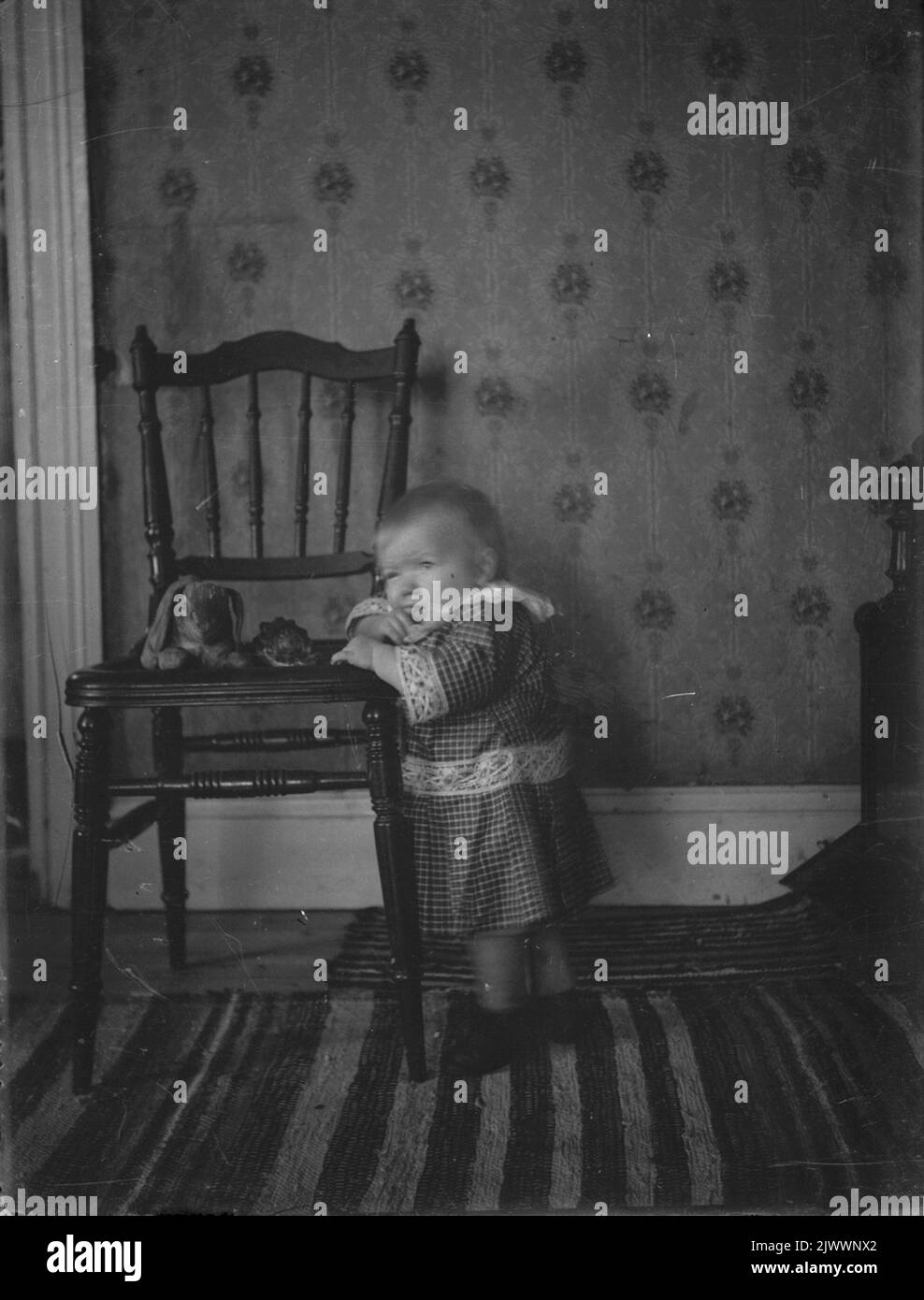 Toddler by chair. Litet barn vid stol Stock Photo - Alamy