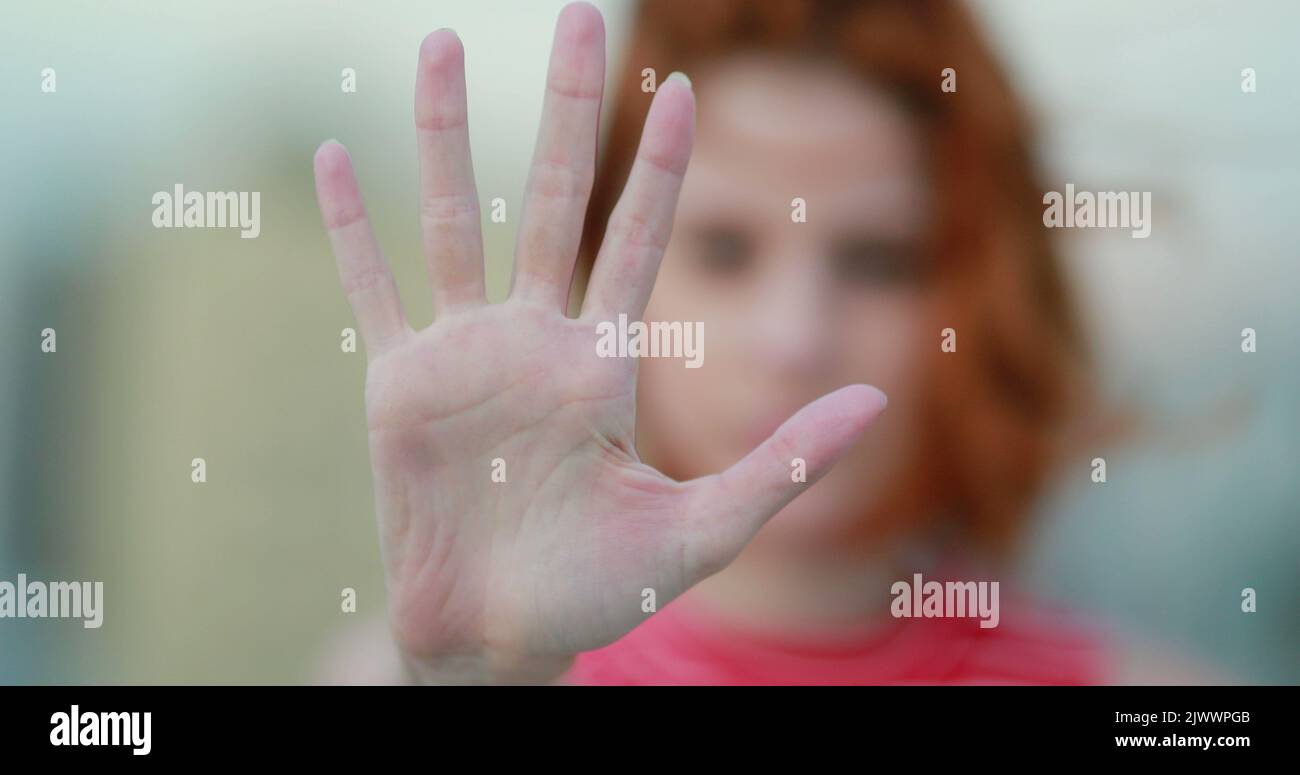 Redhead woman annoyed making stop sign with hand, saying no, expressing ...