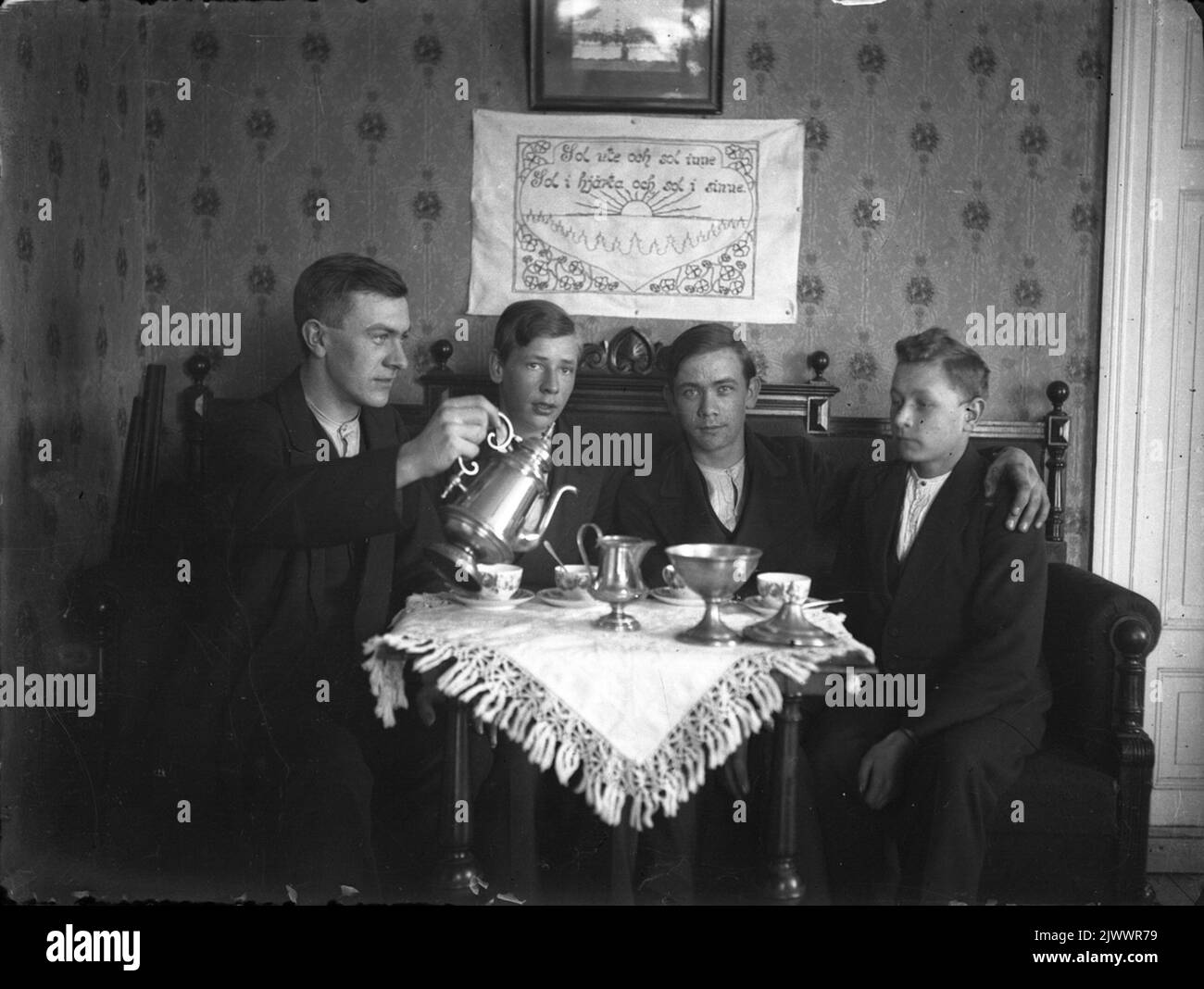 Four young men around a coffee table. Fyra unga män runt ett kaffebord ...