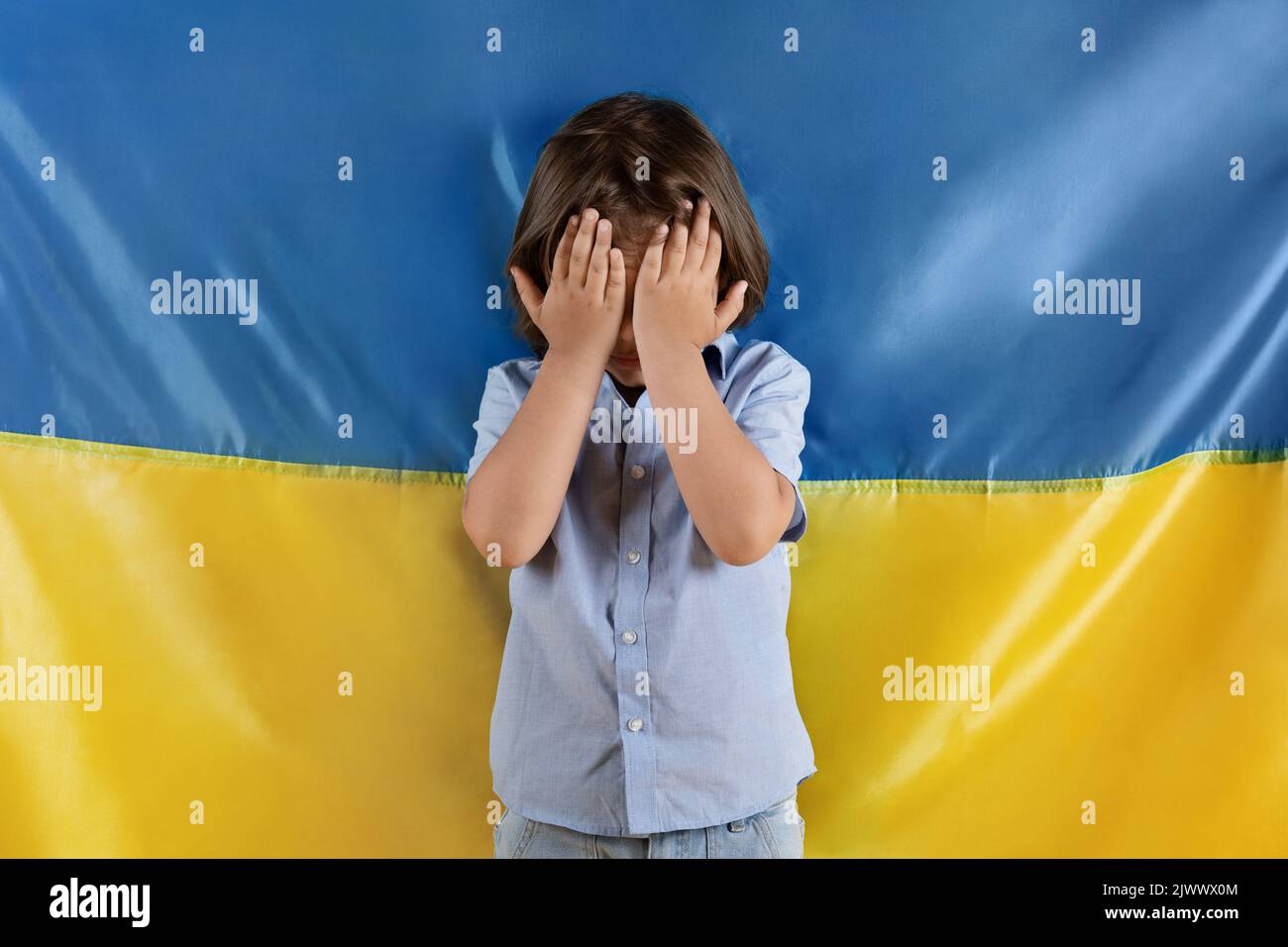 Stop killing kids at war. Little scared boy crying, hiding his face ...