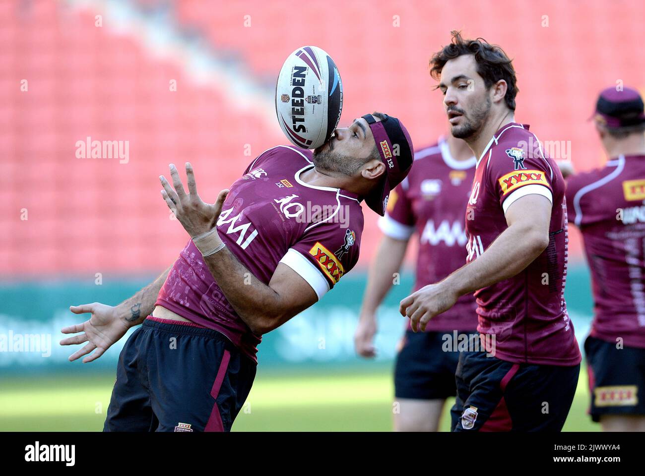 Queensland Maroons player Greg Inglis handles the ball, watched by team ...