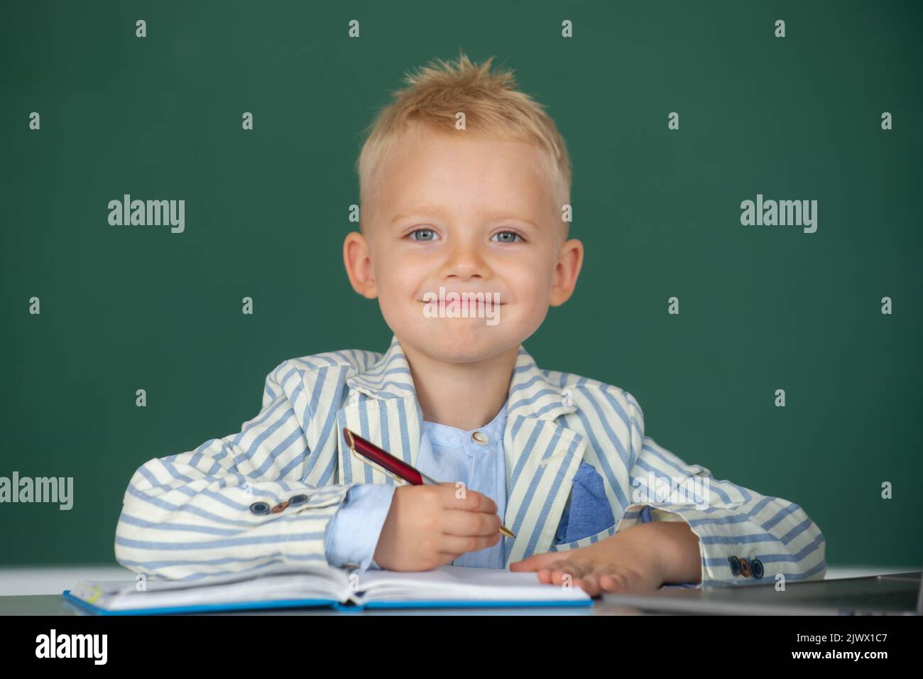 Kid writing in class. Child at school. Kid is learning in class on ...